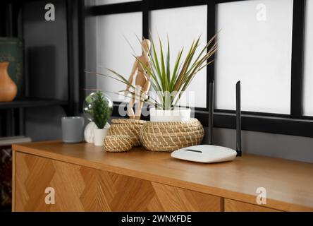 Modern wi-fi router with plants and lamp on shelf in room Stock Photo ...