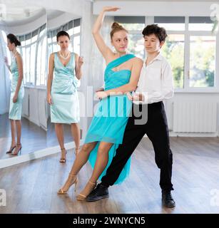Dance teacher teaches a girl and a boy couples ballroom dancing Stock ...