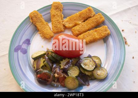 fish sticks with tomato and sautéed courgettes Stock Photo - Alamy