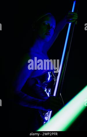 attractive bizarre woman in robotic attire posing with blue LED lamp ...
