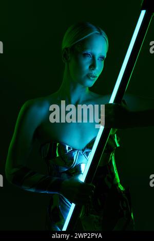 extraordinary woman in metallic robotic attire holding blue LED lamp ...