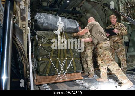 Humanitarian aid pallets rigged with parachutes for airdrop aboard a C ...