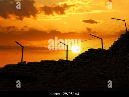 Prison wall and electric fences at sunset. freedom themed photo Stock ...
