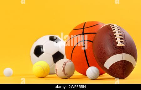Many different sports balls on green grass against black background ...