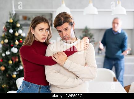 Sad couple listens to their elderly father scream and swear while ...