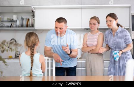 Parents and elder sister scold daughter in kitchen Stock Photo - Alamy