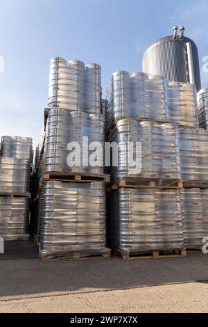 Steel industrial stack of beer kegs against. Modern brewery and ...