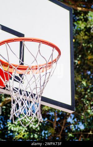 Basketball hoop seen from below with the blue sky and a dunking ball ...