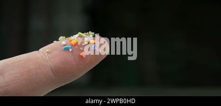 Macro shot of microplastics on human finger. Concept of plastic ...