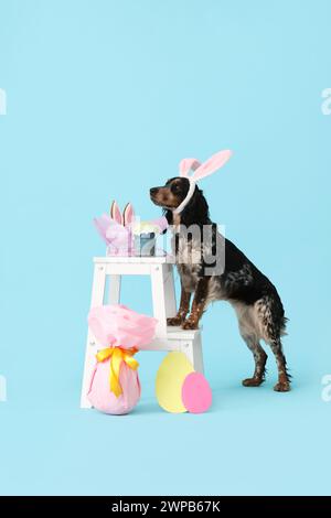 Cute cocker spaniel in bunny ears with Easter gift eggs and beautiful ...
