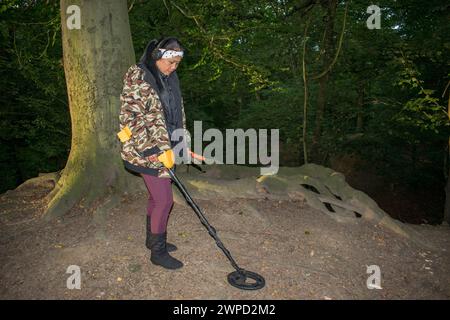 An Asian Female Metal Detecting in a Woodland Forest Stock Photo - Alamy