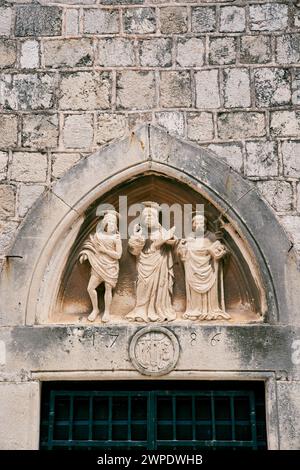 The statues with three saints in front of the main entrance of the ...
