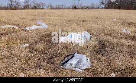 Weathered cardboard box and plastics dumped as trash in a wide open ...