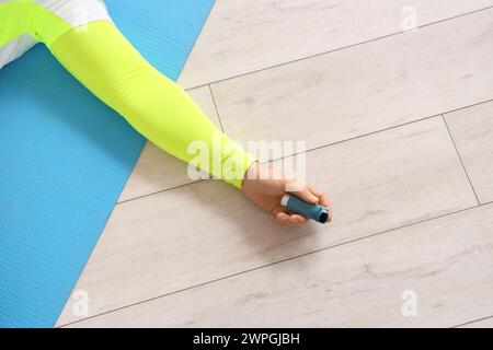 Sporty young man with inhaler lying on floor in gym, closeup Stock ...
