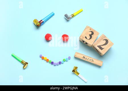 Composition with party whistles and calendar with date 1 APRIL on pink ...