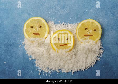Lemon slices with cloves and cinnamon forming a smiley face on a pile ...