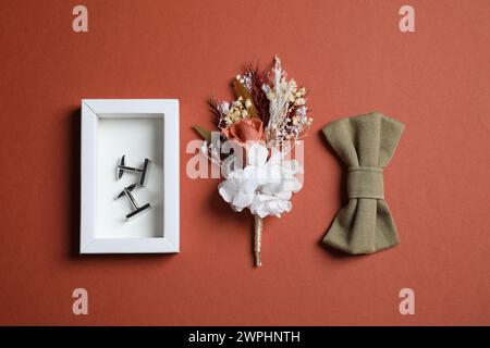 Wedding stuff. Stylish boutonniere, bow tie and wedding rings on gray ...