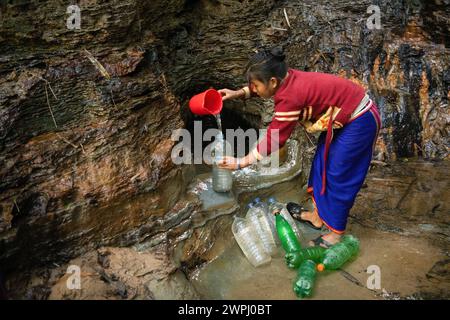 A Mro woman fetches drinking water from a mountain spring. Mro people ...