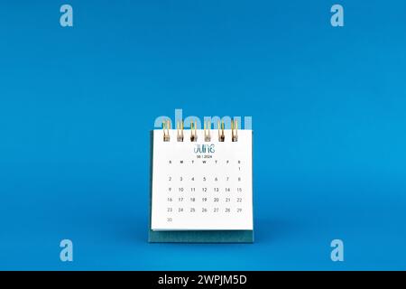 June Mini desk calendar for 2024 year on worktable with pink color ...