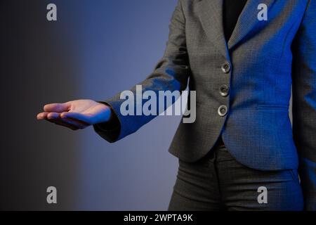 Part of a business woman with her arm extended forward and palm up ...
