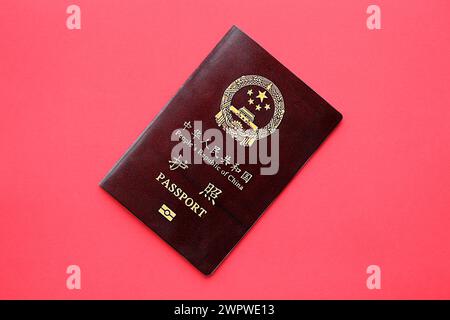 Red passport of People Republic of China. PRC chinese passport on bright background close up ...