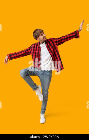 Young tattooed man dancing against yellow background Stock Photo - Alamy