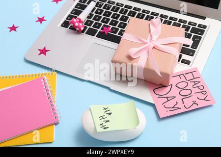 Laptop, notebooks, gift box and sticky notes on wooden background ...