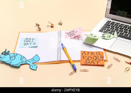 Laptop, notebook, stationery and sticky notes on beige background ...