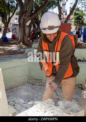Oaxaca, Mexico - A worker chisels a block of stone to use in repairs on ...