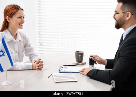 Immigration to Israel. Embassy worker approving visa application form ...