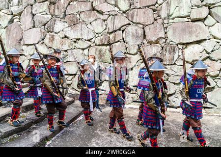 Japanese children dressed as ashigaru soldiers in red armour carrying ...