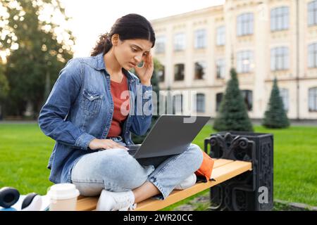Young female student preparing for exams with many books and chained to ...