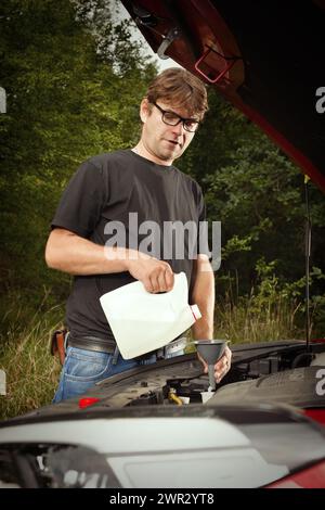 Car driver take care of his car before longer trip and checking oil ...