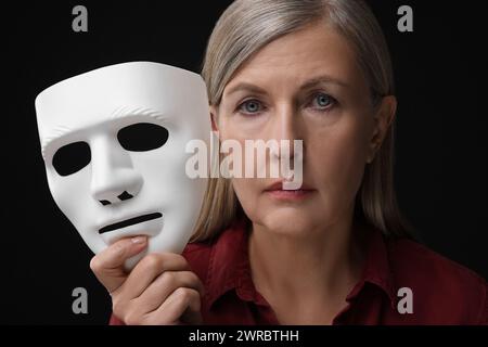 Multiple personality concept. Woman with mask on black background Stock ...