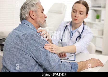 Arthritis symptoms. Doctor examining patient with shoulder pain in ...