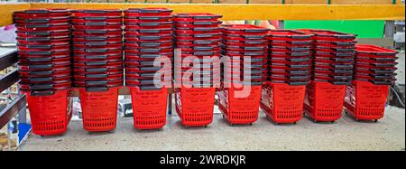 red carts for groceries and other goods are stacked in a supermarket ...