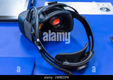 VR headset lays on blue desk, rear view, close up photo with selective ...