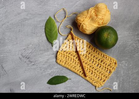 Yellow crochet DIY project. Organic cotton yarn on grey background with ...