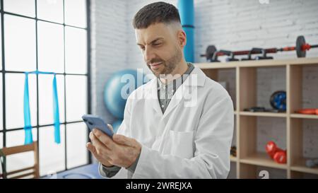 Young hispanic man wearing physiotherapist uniform working at ...