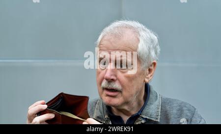 Shocked grey-haired man in eyeglasses posing and looking aside isolated ...