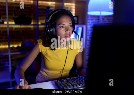 African american woman streamer playing video game using joystick at ...