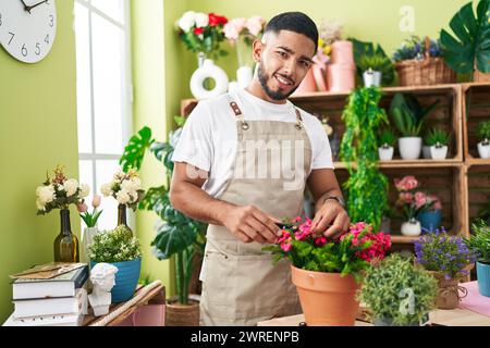 Young latin man florist cutting plants at flower shop Stock Photo - Alamy