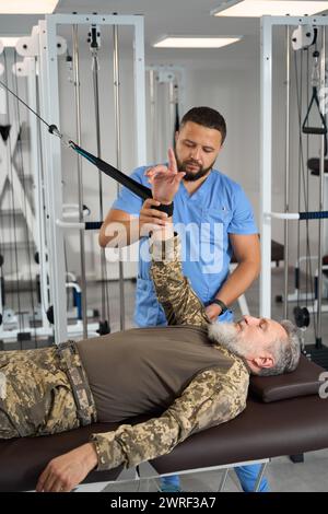 Military patient does exercises to stretch his arm muscles Stock Photo ...