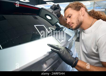 Young man conducts a check inspection of a car body Stock Photo - Alamy