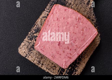 Delicious canned pink ham with salt, spices and herbs on a dark ...