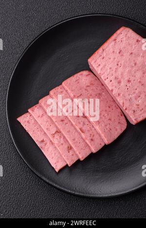 Delicious canned pink ham with salt, spices and herbs on a dark ...