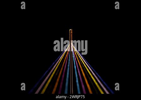 Rainbow Colored Threads Through Needle Eyelet on red background Stock ...