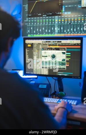 Musician and producer work on soundboard pads at professional studio ...