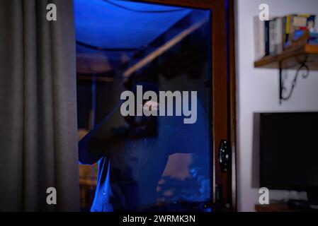 The thief looks through the glass inside the house Stock Photo - Alamy