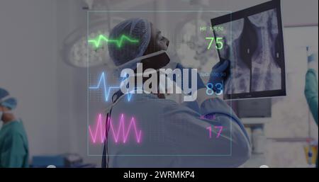 Image of vital signs readings over biracial male surgeon at work in ...
